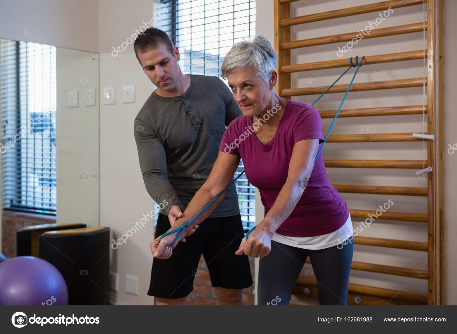 Physiotherapist helping patient in performing exercise — Stock Photo ...