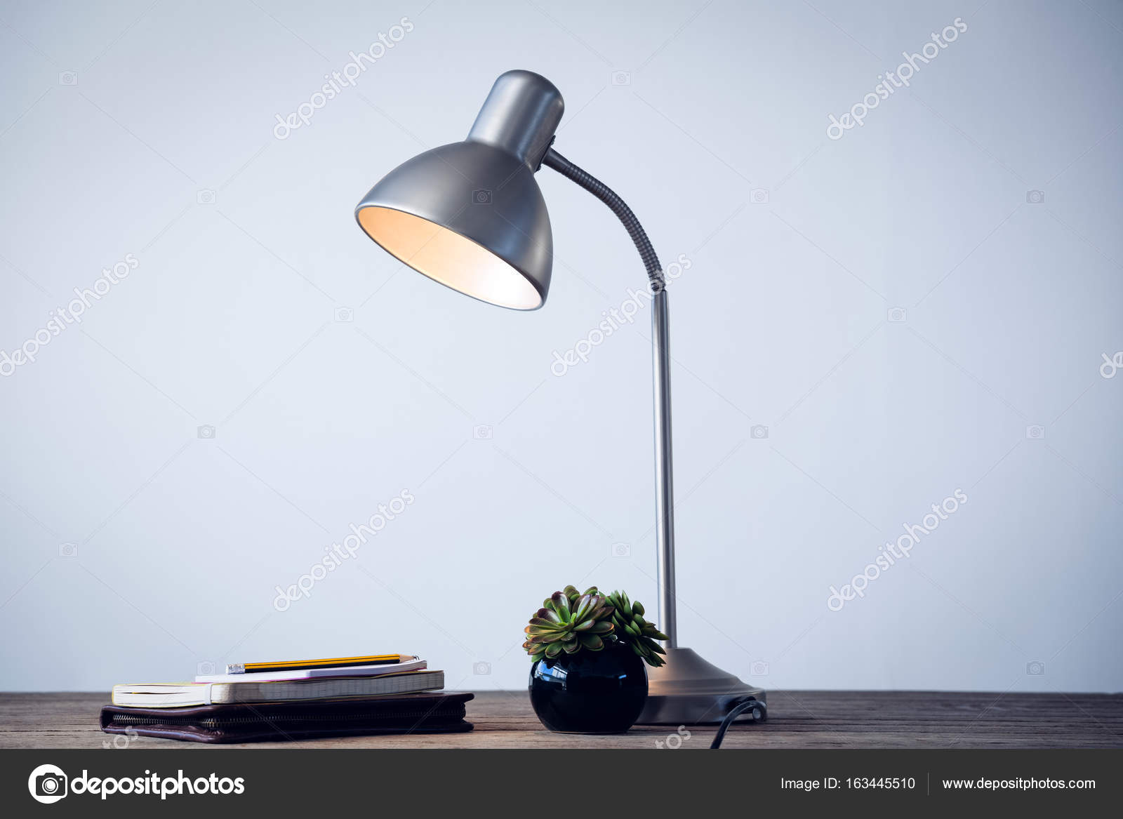 Illuminated desk lamp by books on table — Stock Photo © Wavebreakmedia ...