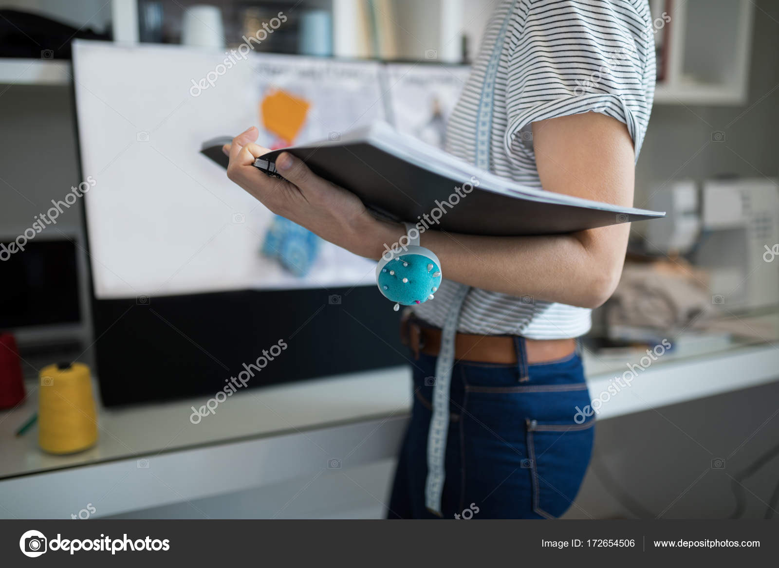 Female designer holding book Stock Photo by ©Wavebreakmedia 172654506