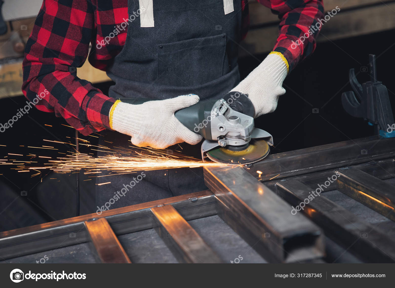 Woman working with angle grinder cuts and polishes metal after welding ...