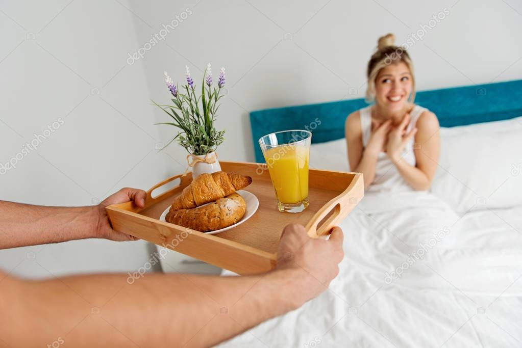 Hombre trayendo el desayuno a su novia en la cama 2022