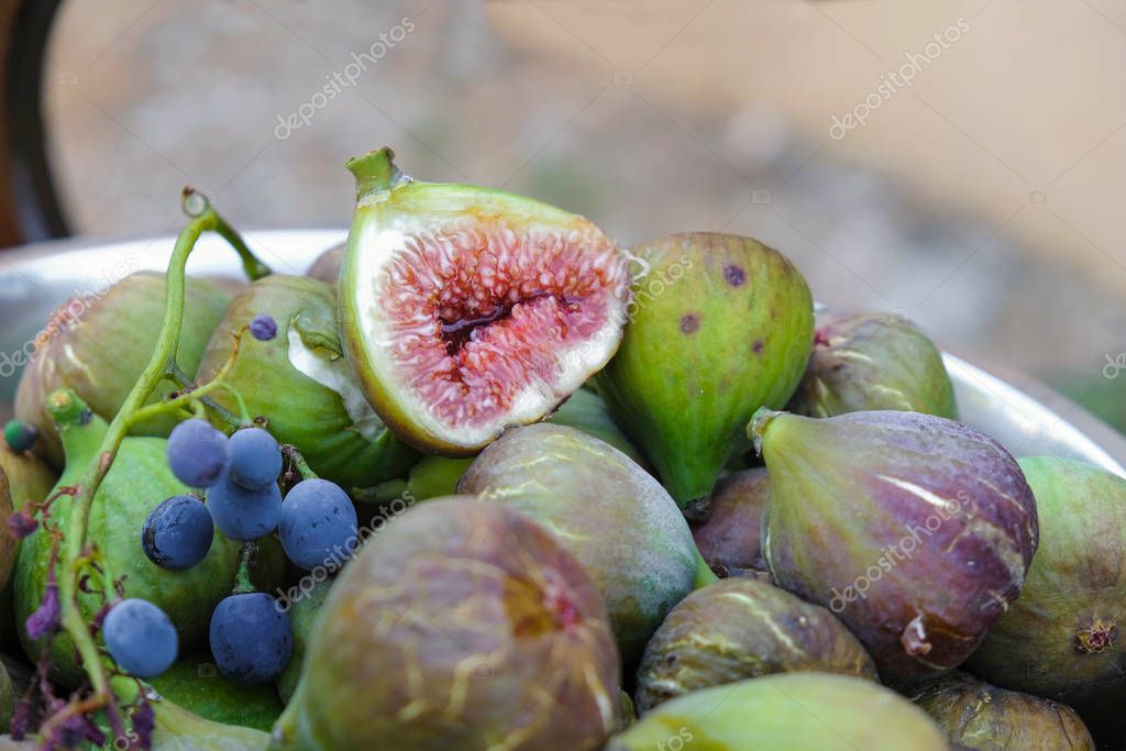 Bodegón de higos maduros y uvas azules. La fruta cortada en rodajas del ...