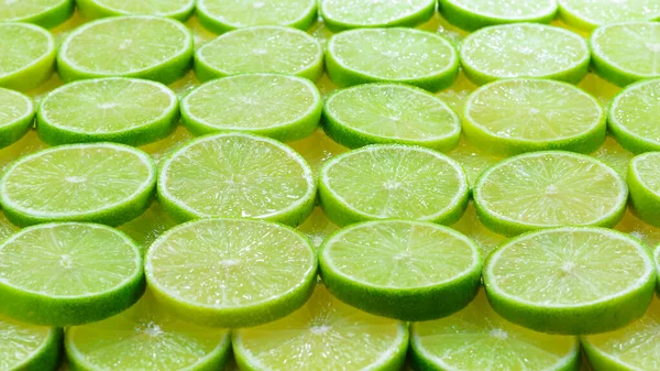 Fresh lime slices as a background. - Stock Image - Everypixel