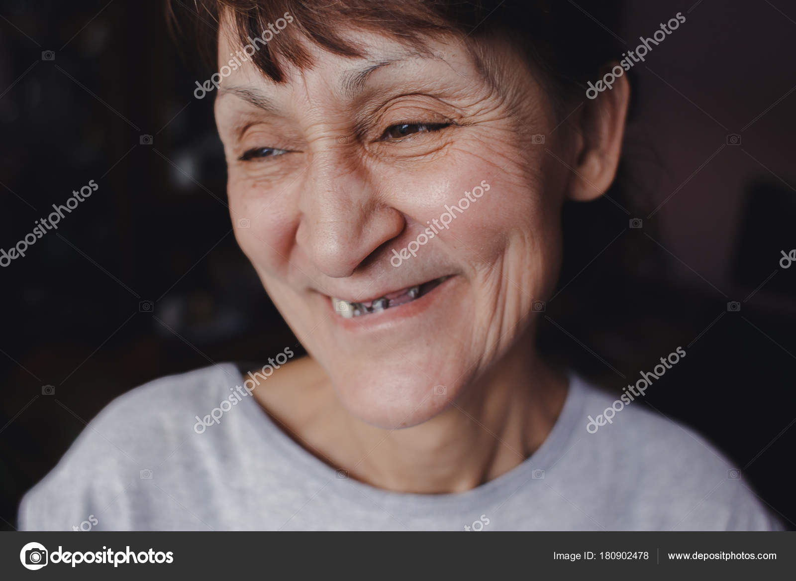 A woman with bad teeth smiles happily. Stock Photo by ©kleoppo 180902478