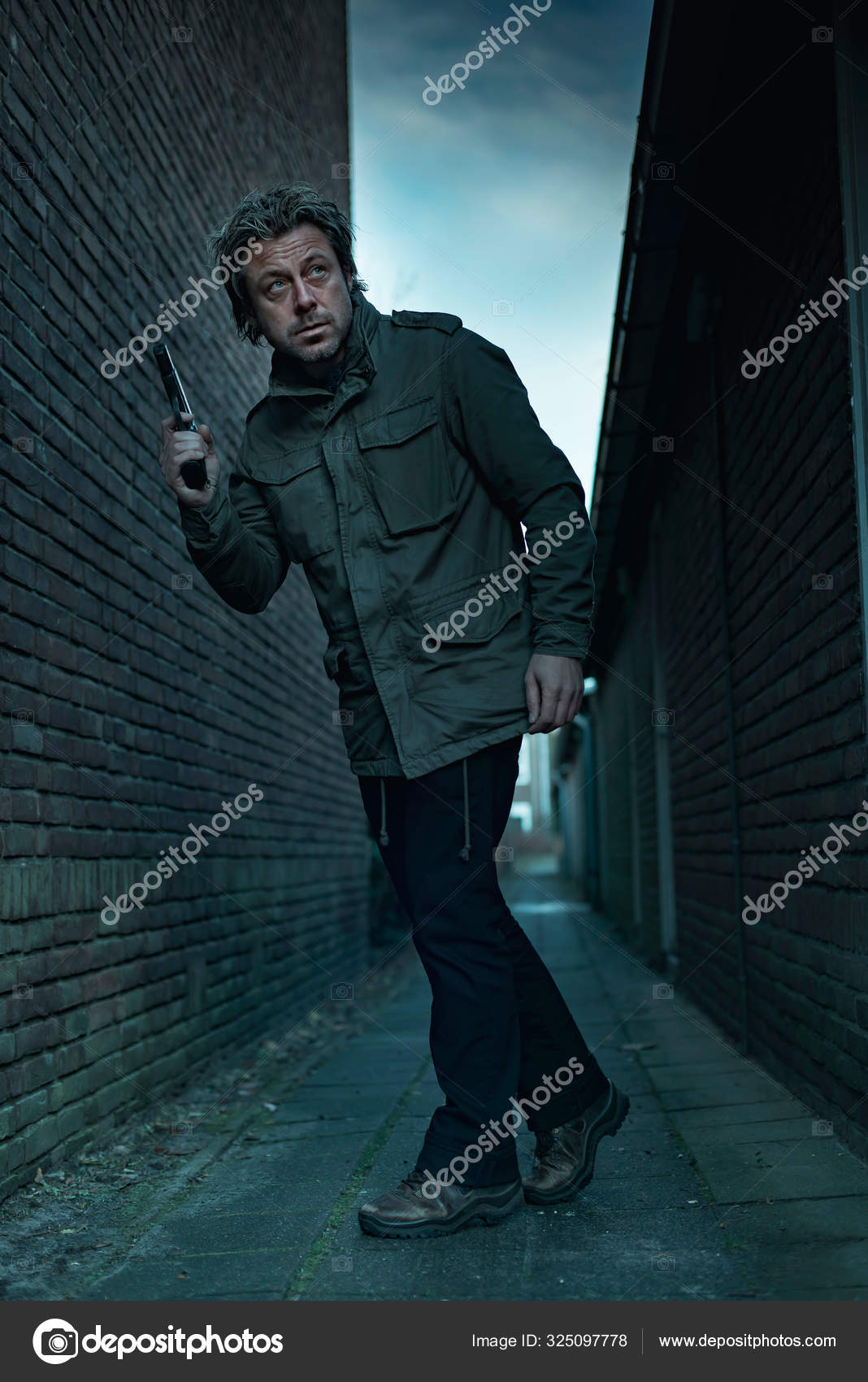 Man with pistol sneaking in dark urban alley. — Stock Photo © ysbrand ...