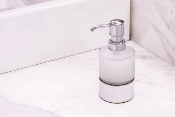 White liquid soap in dispenser on the table in the water closet room ...