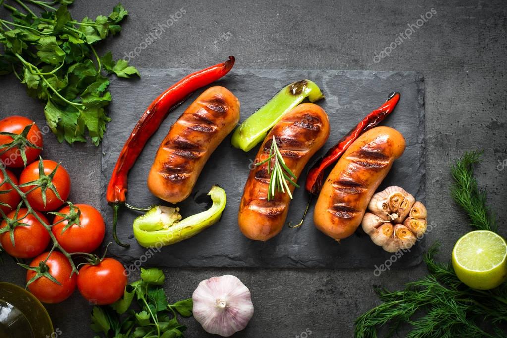 Embutidos a la brasa fritos con verduras al fondo negro 2024