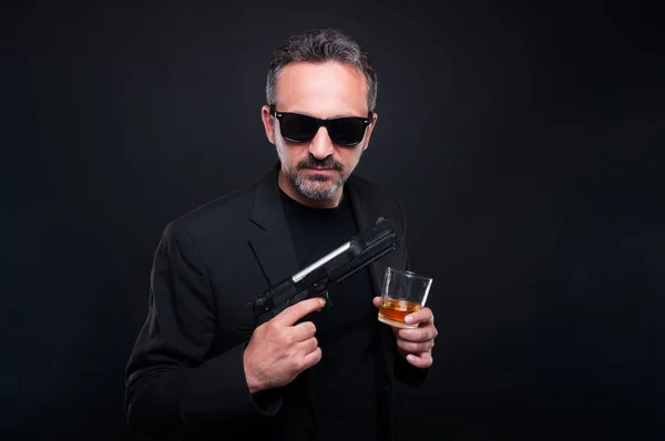 Dangerous bald gangster man with beard holding gun. Wearing blac ... Dangerous bald gangster man with beard holding gun. Wearing blac ...