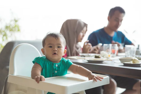 Cute little girl sitting on high chair Stock Photo by ©odua 150590426