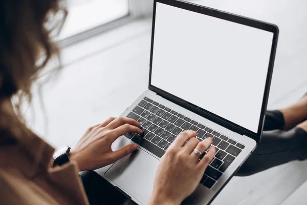 Female hands typing on the laptop. White blank laptop screen with space ...
