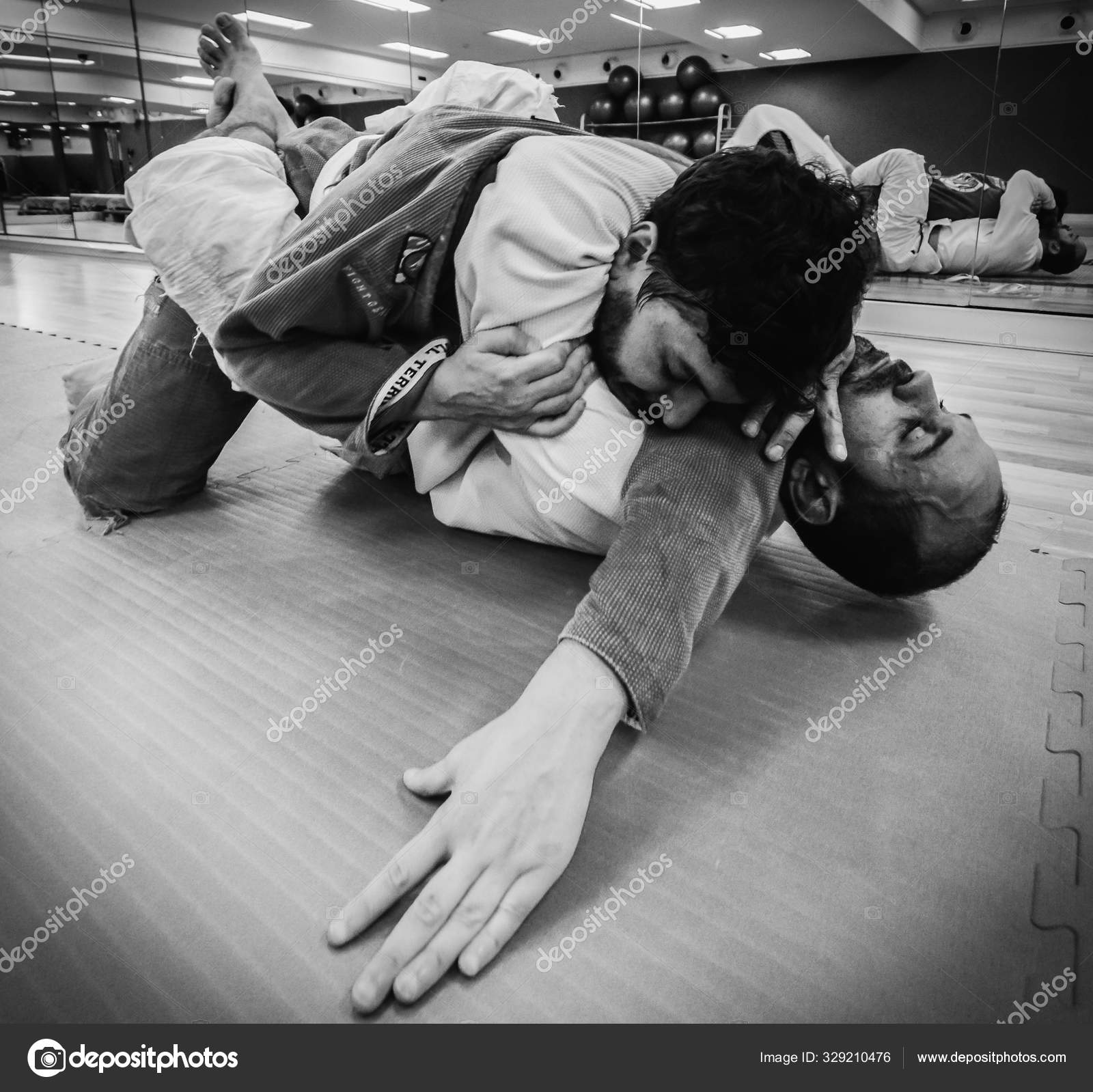 Two young men practice Brazilian Jiu-Jitsu sparring, a grappling type ...