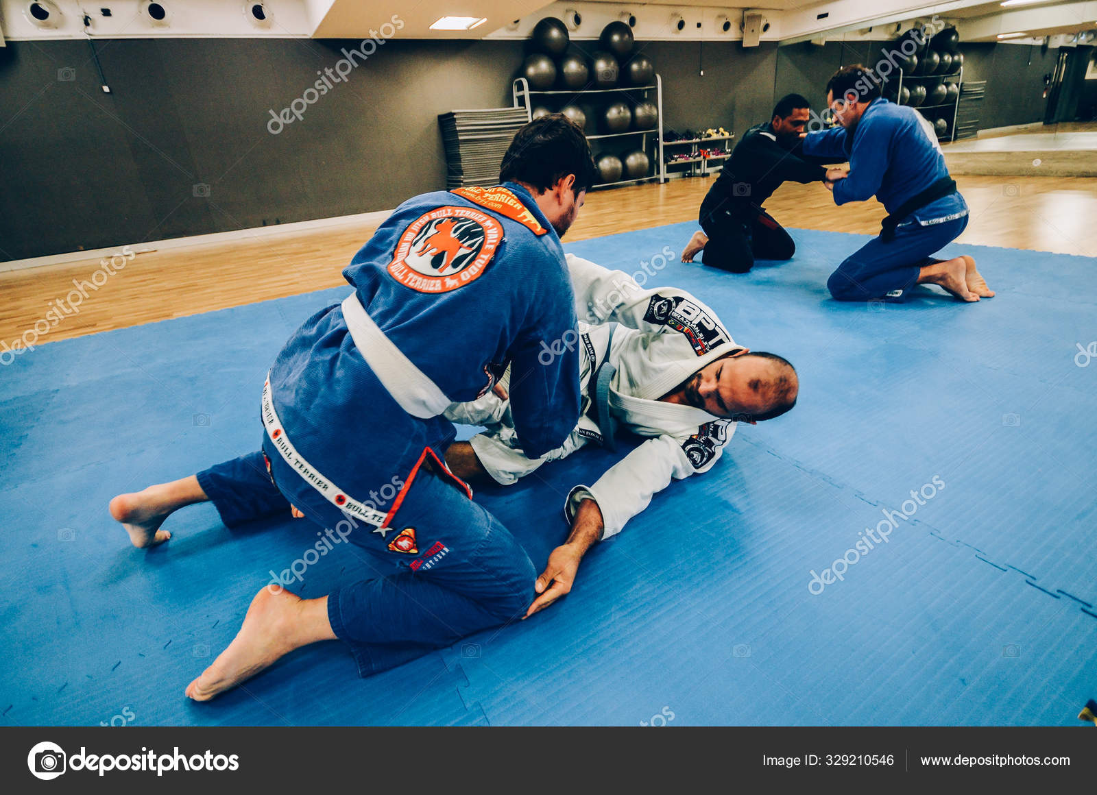 Two young men practice Brazilian Jiu-Jitsu sparring, a grappling type ...