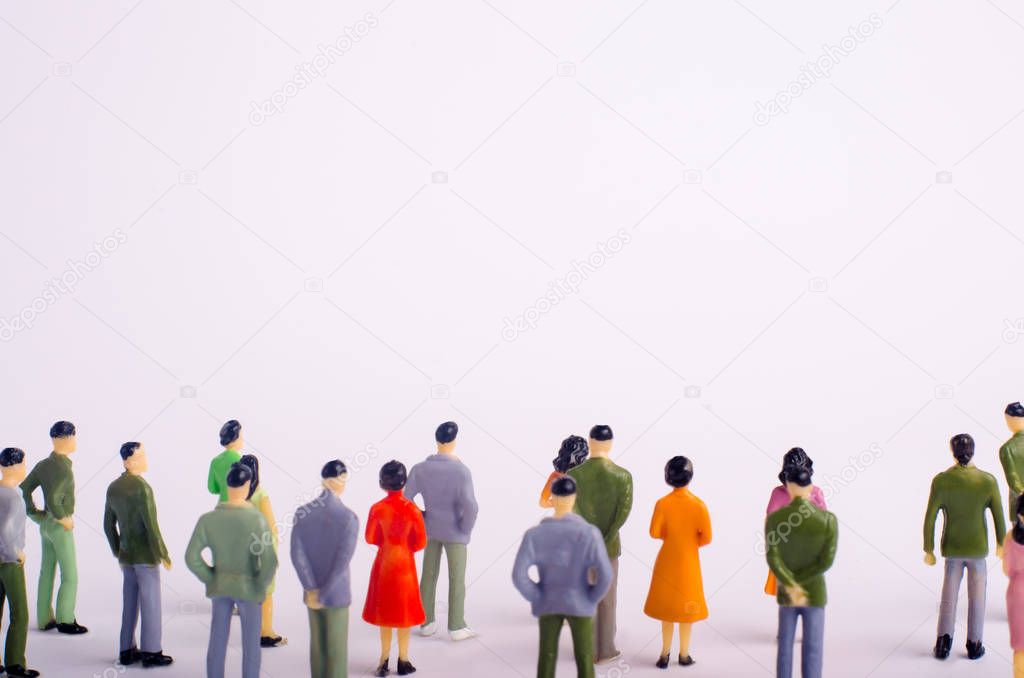 Una multitud de personas está de pie y mirando el fondo blanco. La ...