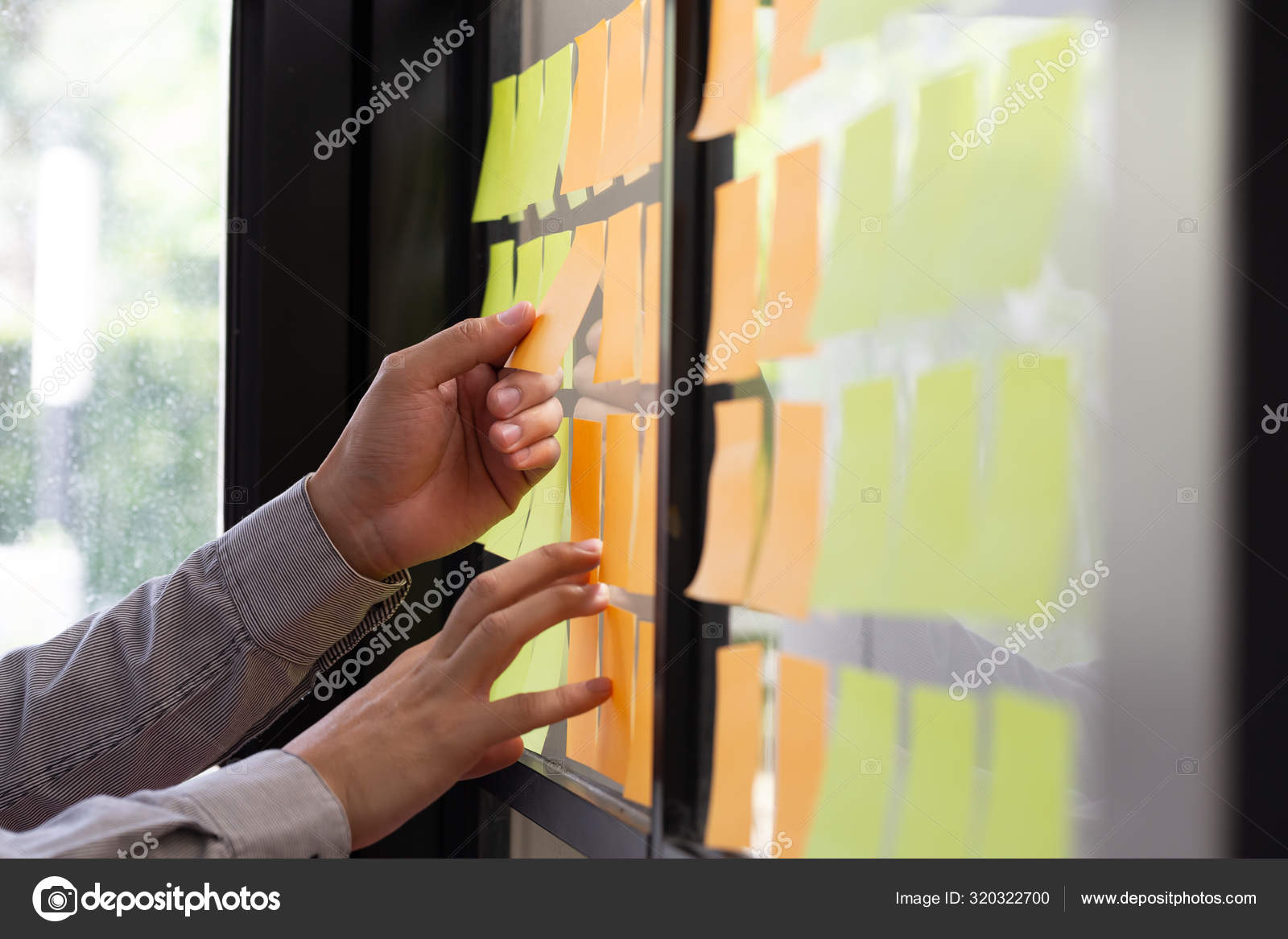 IT worker tracking his tasks on kanban board. Using task control of ...