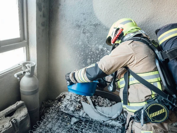 Firefighter spills water on the mattress in a home fire - Stock Image ...