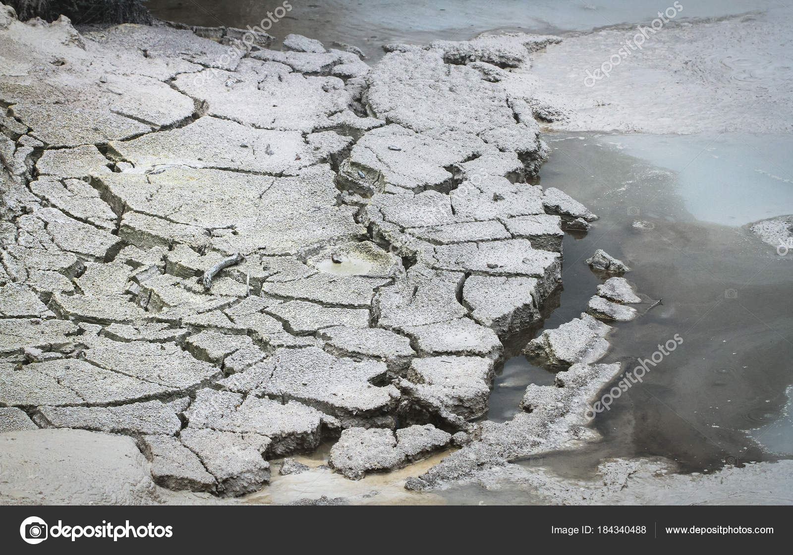 The mud on the edge of this large mud pit cracks and splinters as it ...