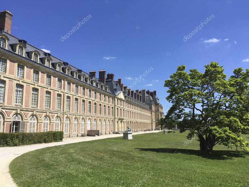 vista diurna de un árbol y estatuas en el patio de un edificio antiguo 2024