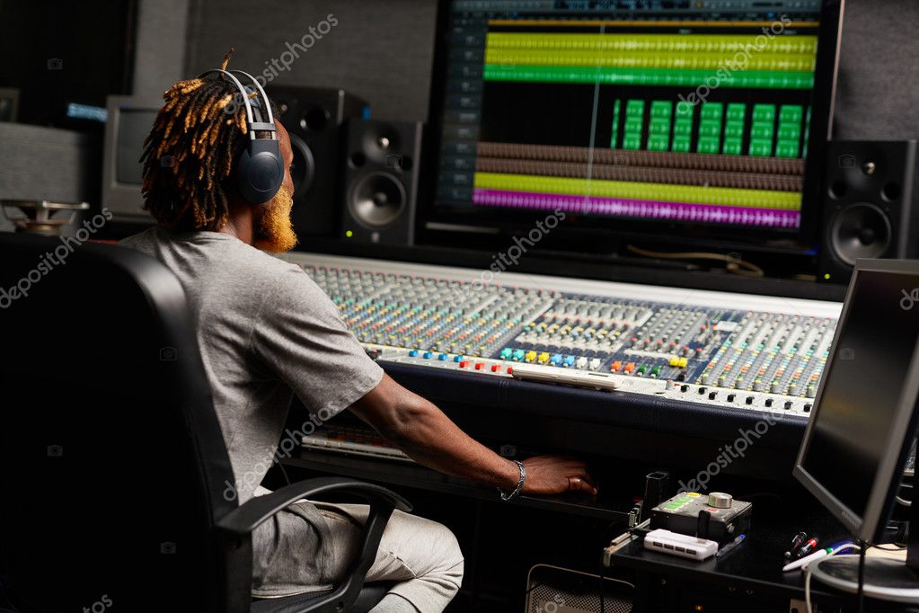 Sound producer sitting by mixing equipment Stock Photo by ©pressmaster ...