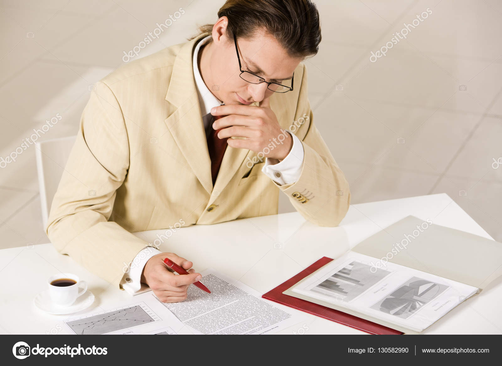 Thinking businessman reading Stock Photo by ©pressmaster 130582990
