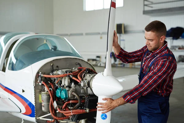Portrait of modern aircraft engineer repairing jet plane in hangar ...