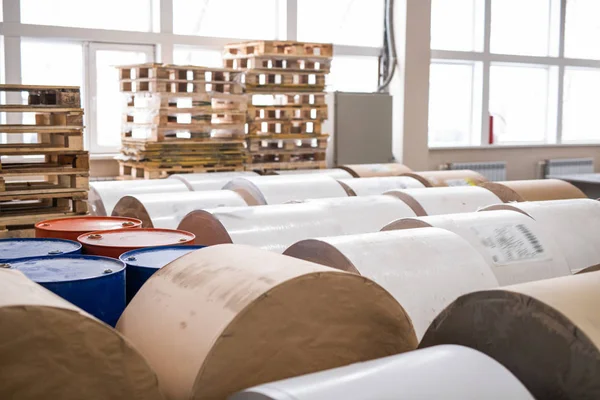Printing house warehouse with packaged paper rolls and stacks of wooden ...
