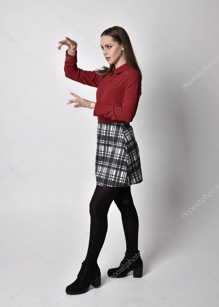 retrato de cuerpo entero de una guapa morena con camisa roja y falda a ...