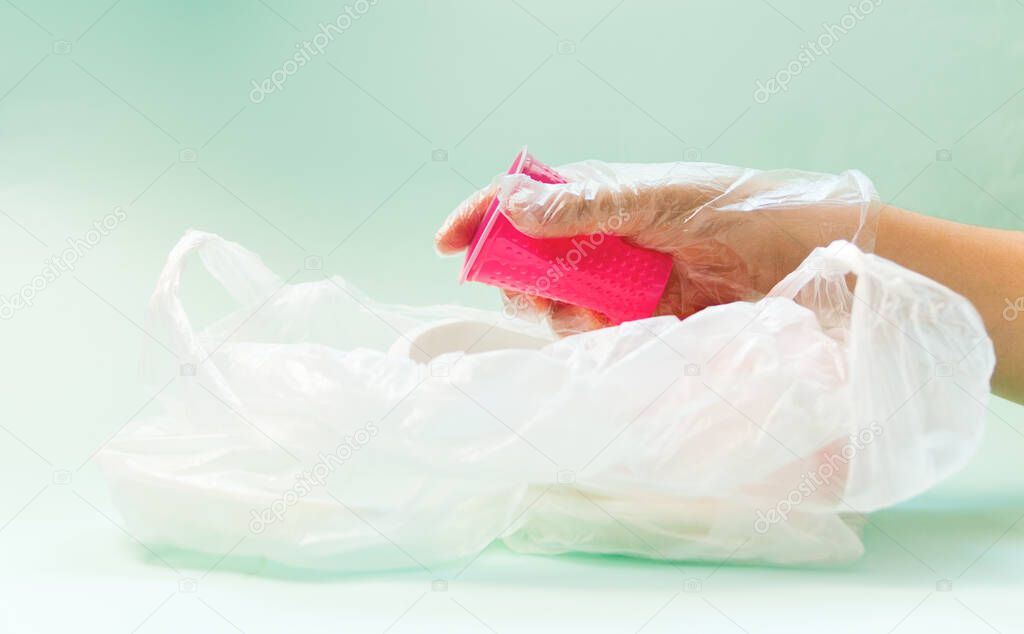 Desperdicio pl stico de vidrio rosa en una mano enguantada sobre un fondo azul. Concepto de ...