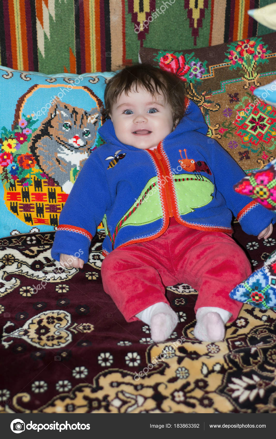 Amazing little girl sitting in bed on a bed with embroidered pillows ... Amazing little girl sitting in bed on a bed with embroidered pillows ...