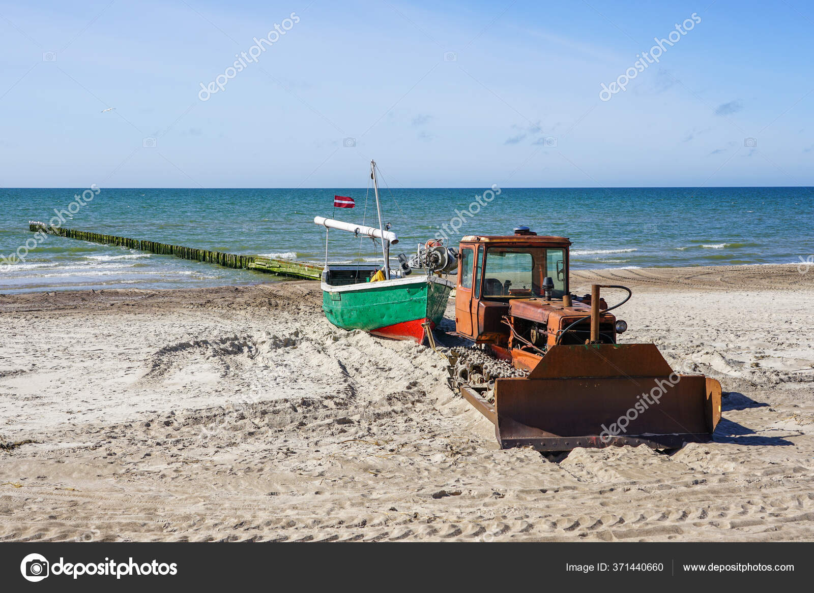 A heavy bulldozer pulls a fishing boat out of the sea — Stock Photo ...