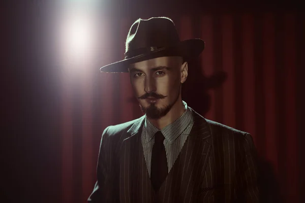 Portrait of a handsome man in elegant classical suit and a hat standing ...