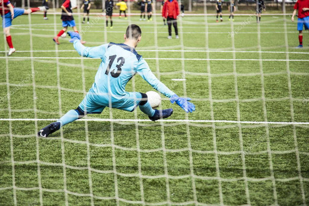 irreconocible joven portero protegiendo el gol en el campo de fútbol ...