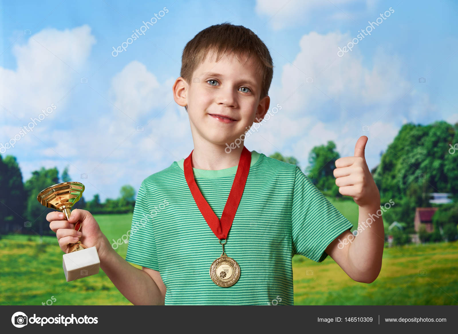 Boy winner with cup and medal on nature Stock Photo by ©ryzhov 146510309