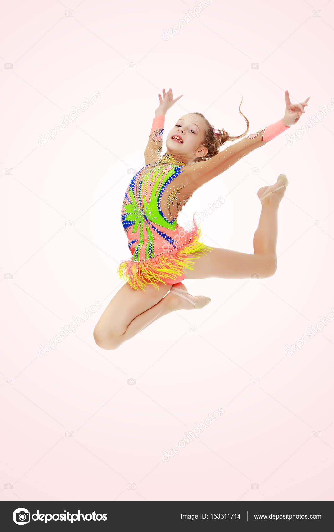 Girl gymnast performs a jump. Stock Photo by ©lotosfoto1 153311714