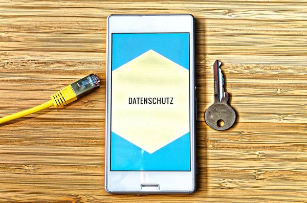Mobile phone on the data protection stands with a key and a yellow LAN ...