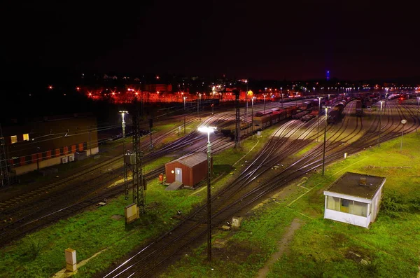 Freight yard at night with grass tracks and parked trains for ...