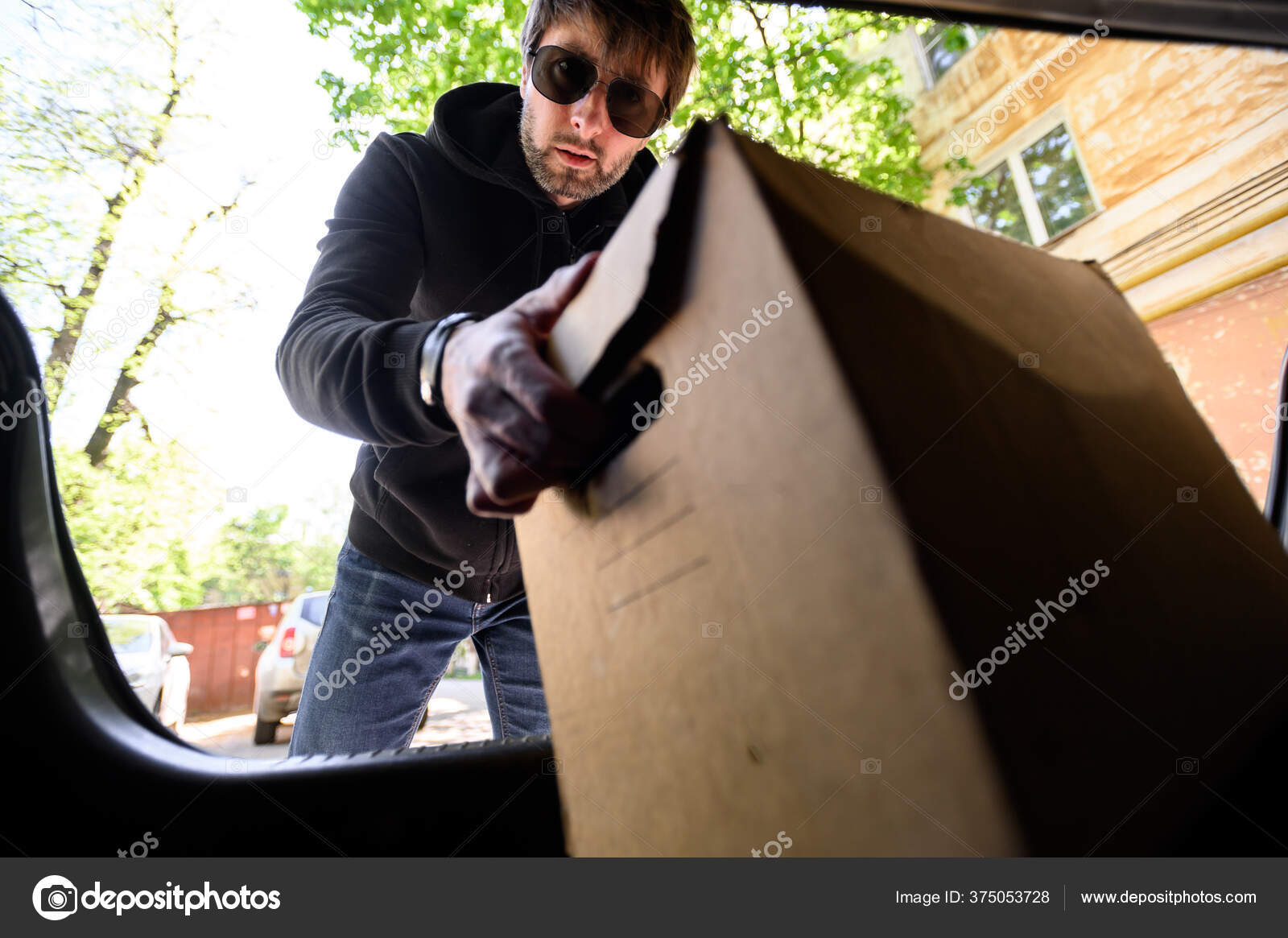 Young man puts a box in the car — Stock Photo © deniskalinichenko ...