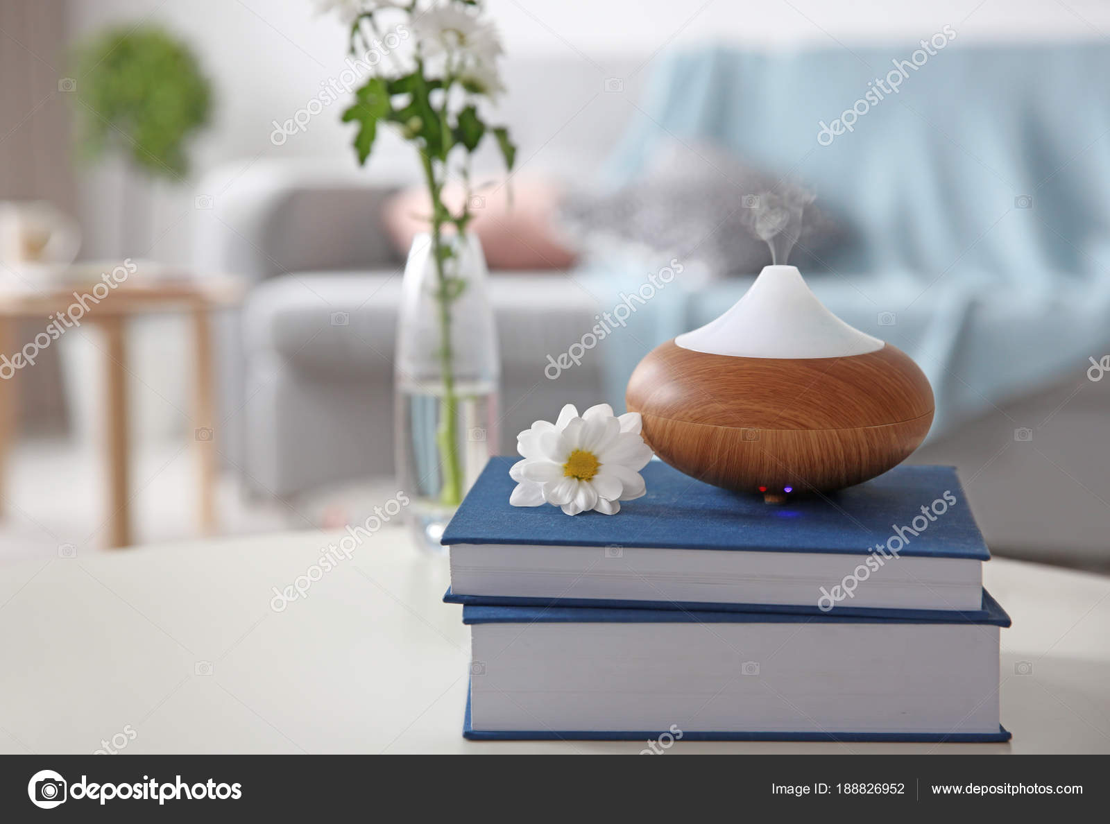 Aroma oil diffuser on stack of books against blurred background Stock ...