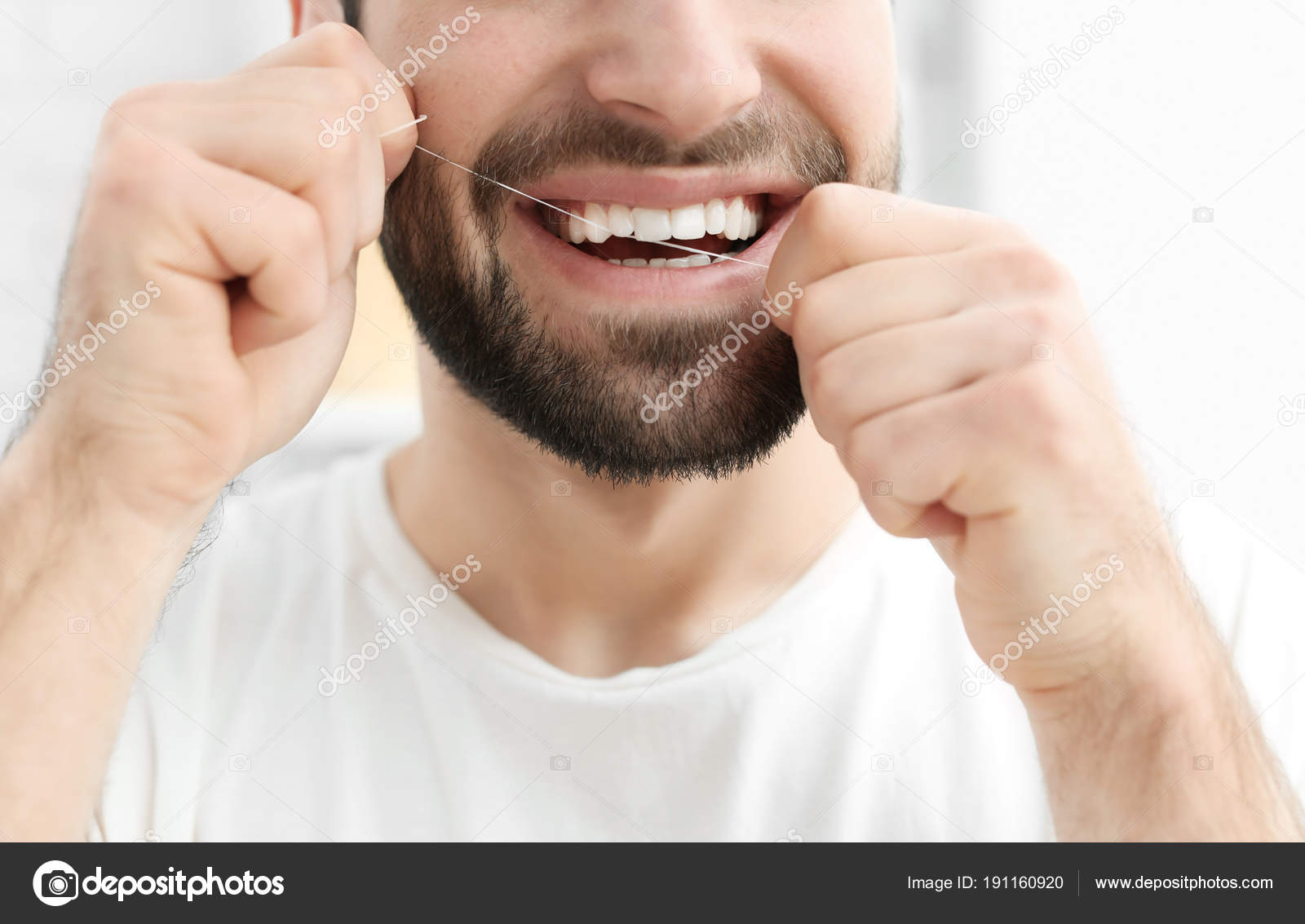Young man flossing his teeth indoors Stock Photo by ©NewAfrica 191160920