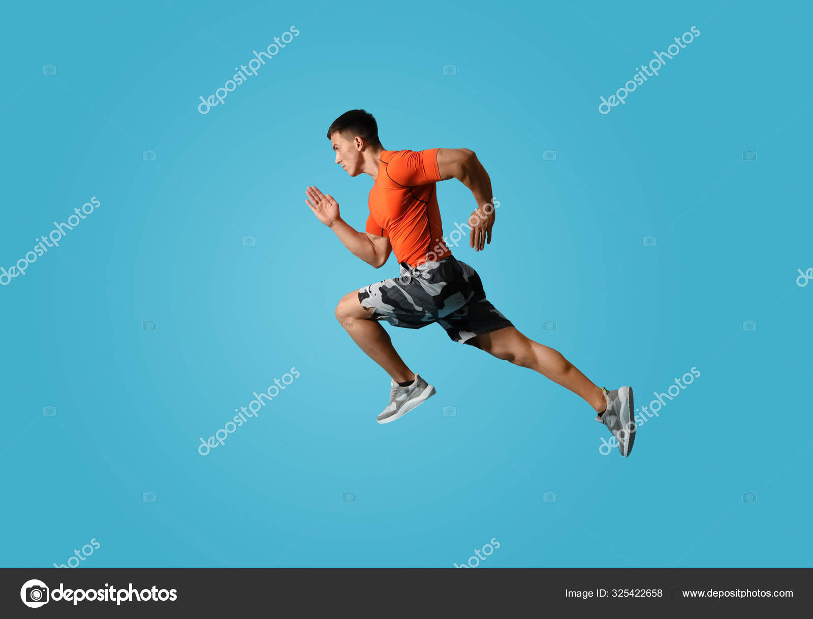 Athletic young man running on light blue background, side view — Stock ...