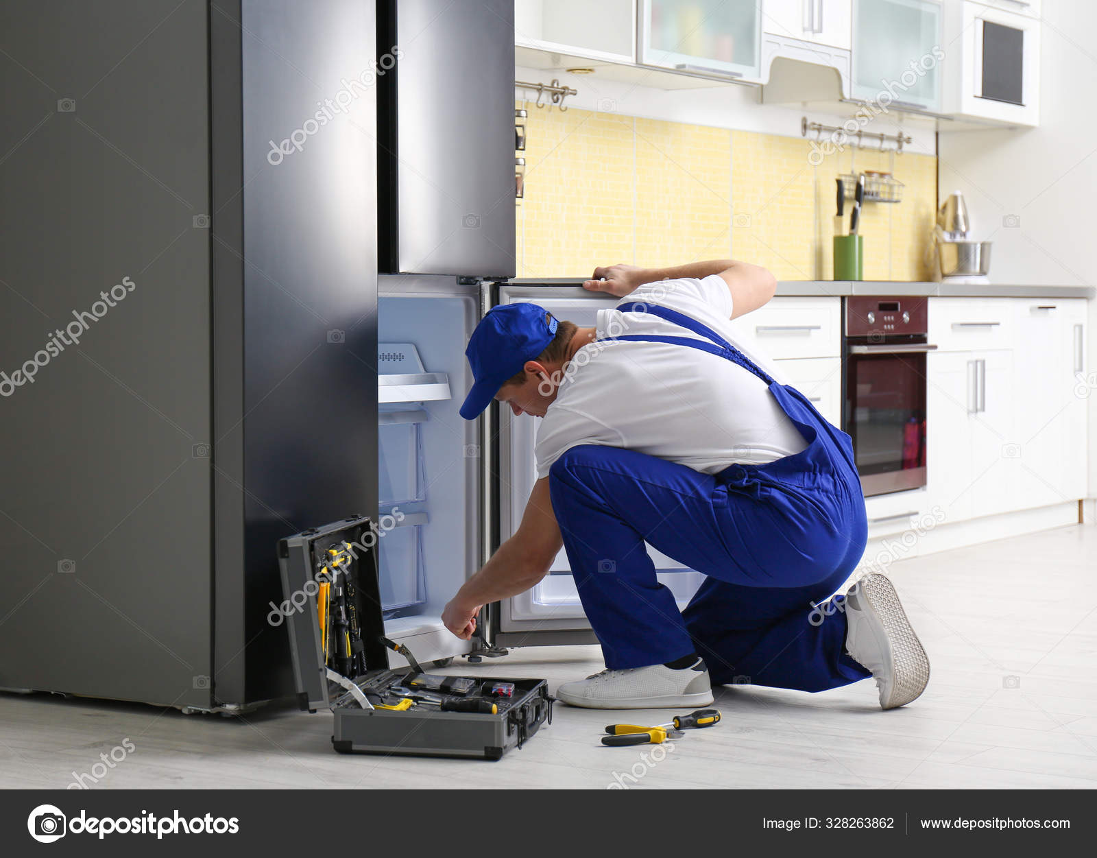 Male technician repairing broken refrigerator in kitchen — Stock Photo ...