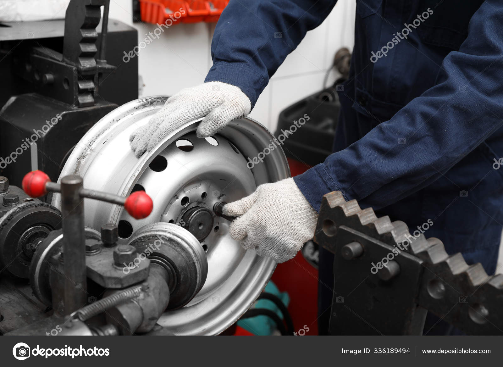 Man working with car disk lathe machine at tire service, closeup ...
