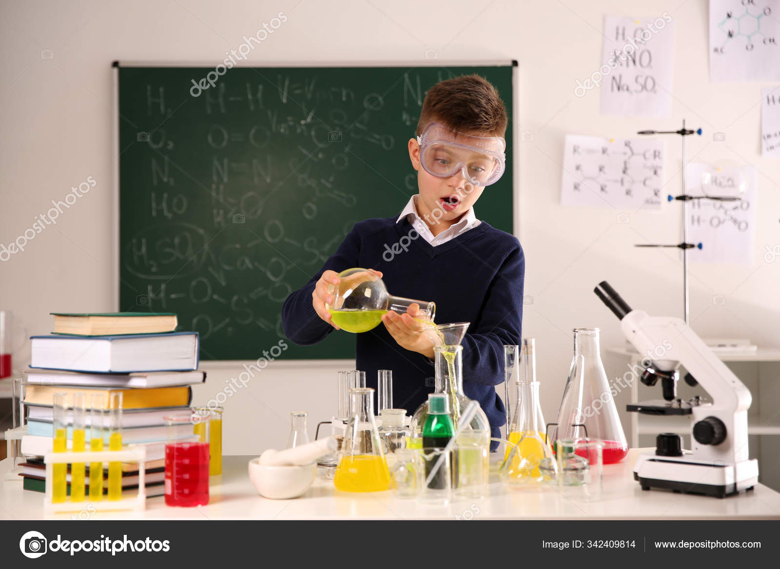 Schoolchild making experiment at table in chemistry class Stock Photo ...