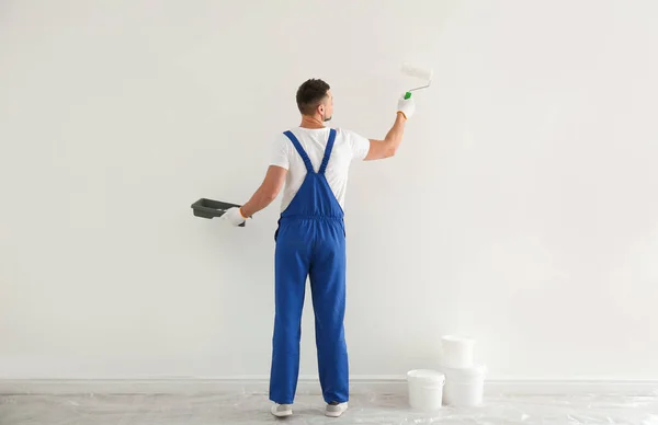 Man painting wall with white dye indoors, back view - Stock Image ...