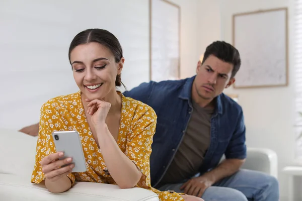 Young man preferring smartphone over his girlfriend at home Stock Photo ...