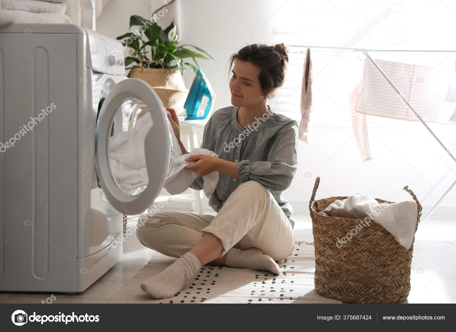 Young Woman Taking Laundry Out Washing Machine Home Stock Photo by ...