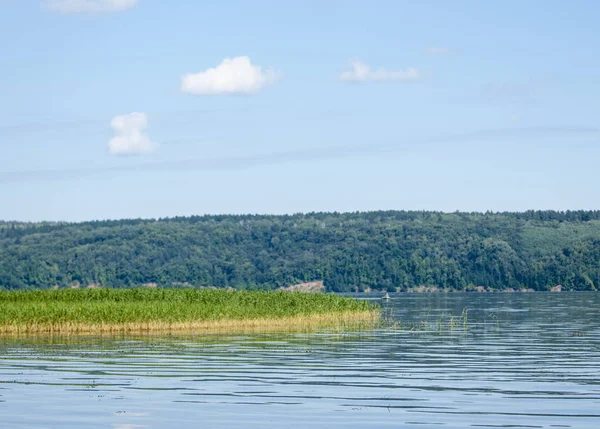 Summer clouds river reeds trees. a large natural stream of water ...