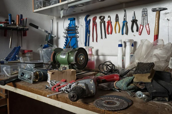 Messy workshop, complete chaos on workbench, unorganised basement or ...