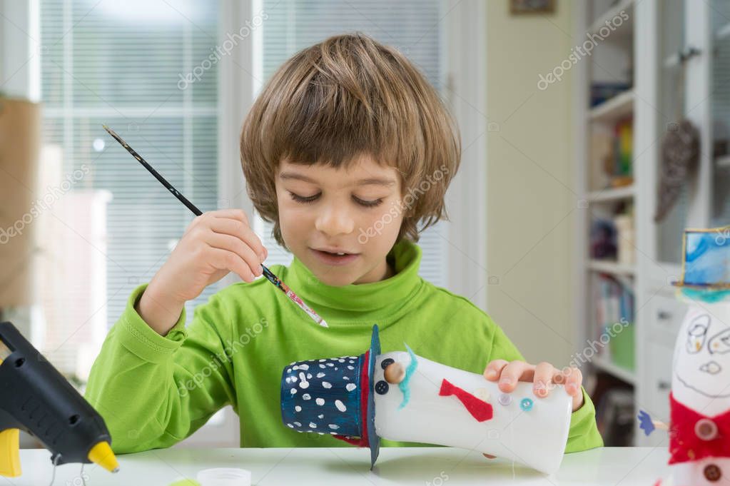 El niño pequeño es creativo haciendo juguetes caseros de la botella de ...