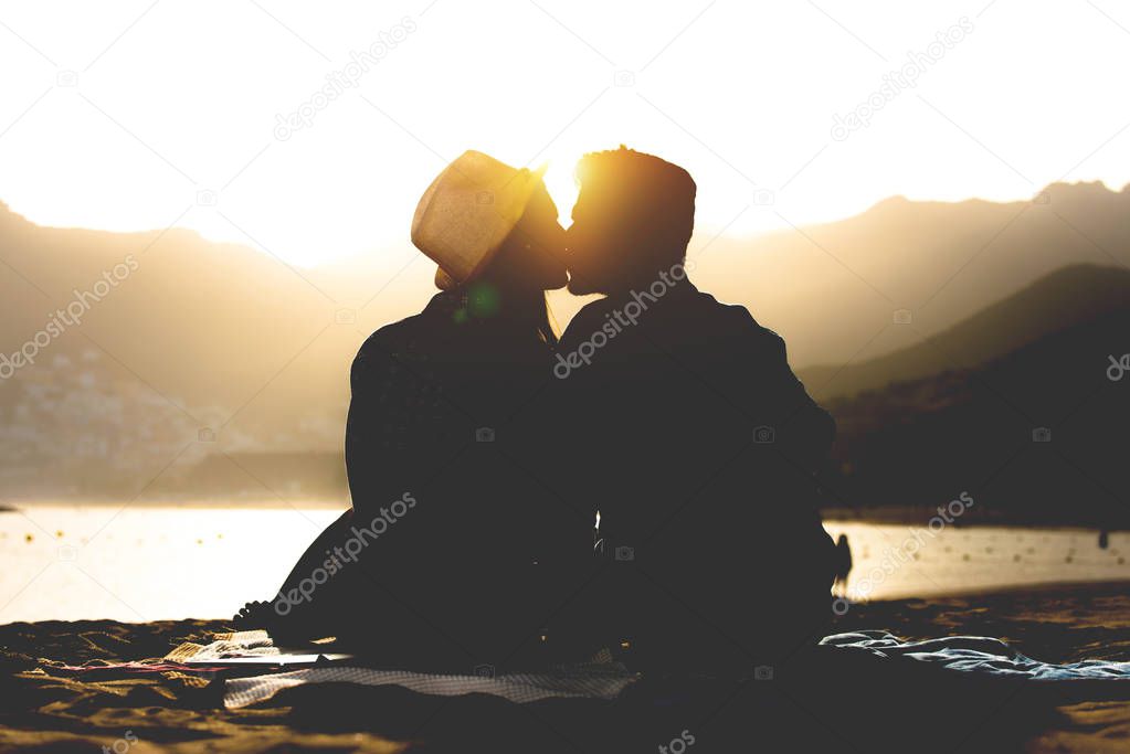 Romántica pareja joven besándose en la playa al atardecer - Silueta de ...