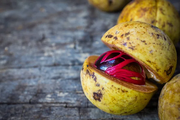Nutmeg with placenta-like cover of seed of myristica fragrant on wooden ...